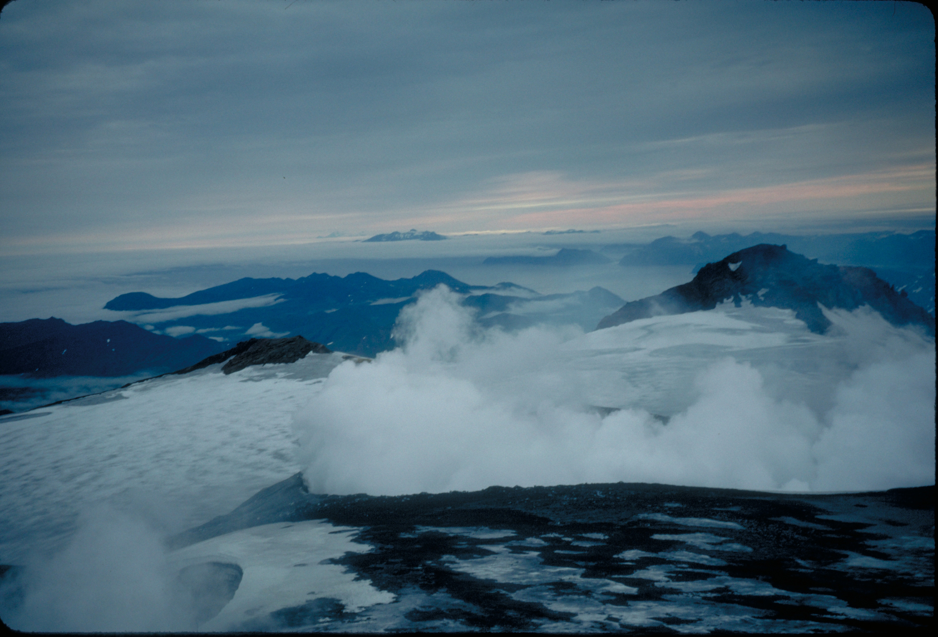 Steam plumes at the summit of Makushin Volcano. Ash blankets the snow ...