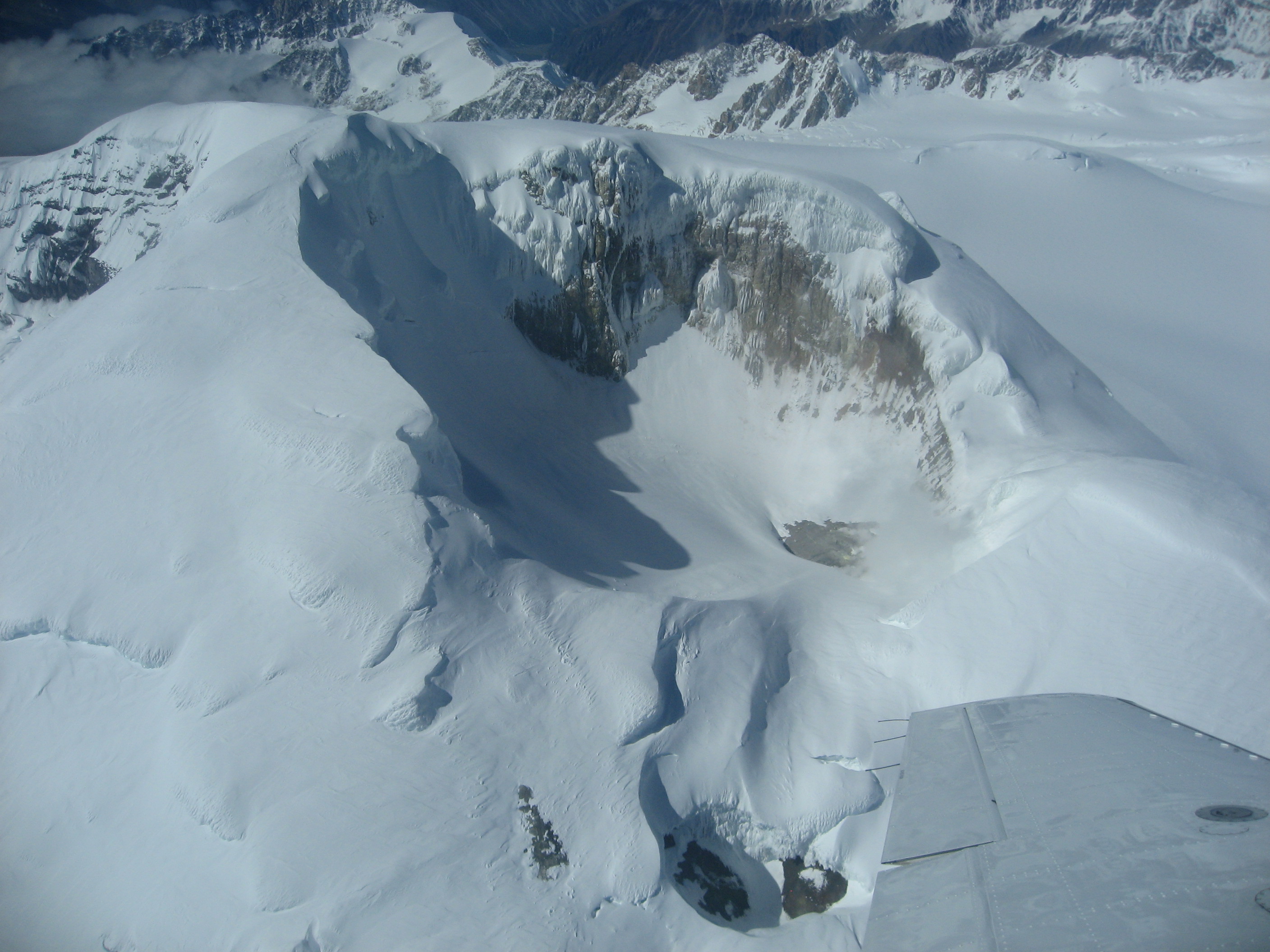 Aerial view from SE into summit crater of Mount Spurr volcano. Snow is ...
