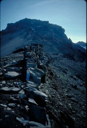 Geologists stand on a dike exposed on a flank of Makushin Volcano. The ...