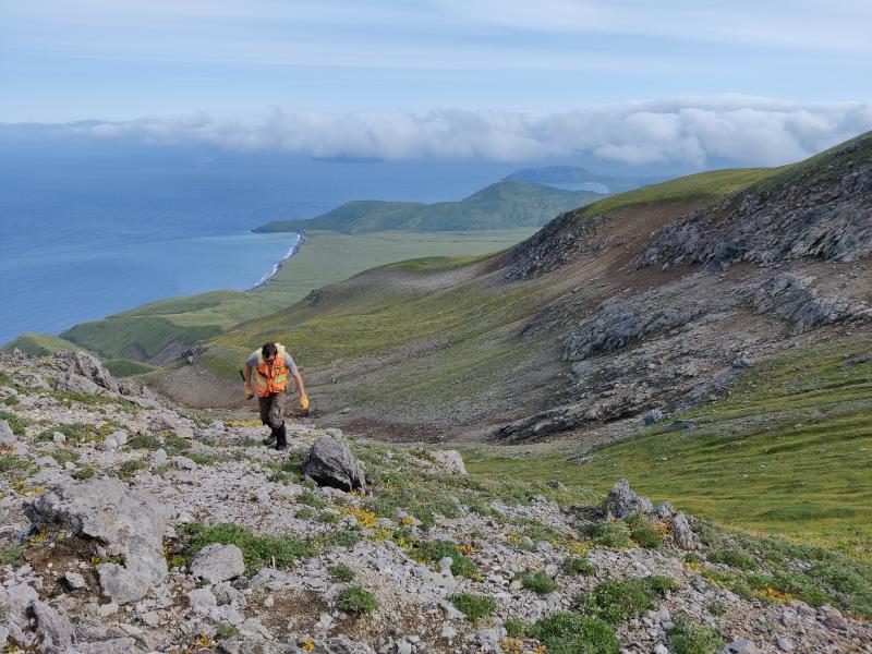 AVO personnel search for an appropriate location to collect rock ...