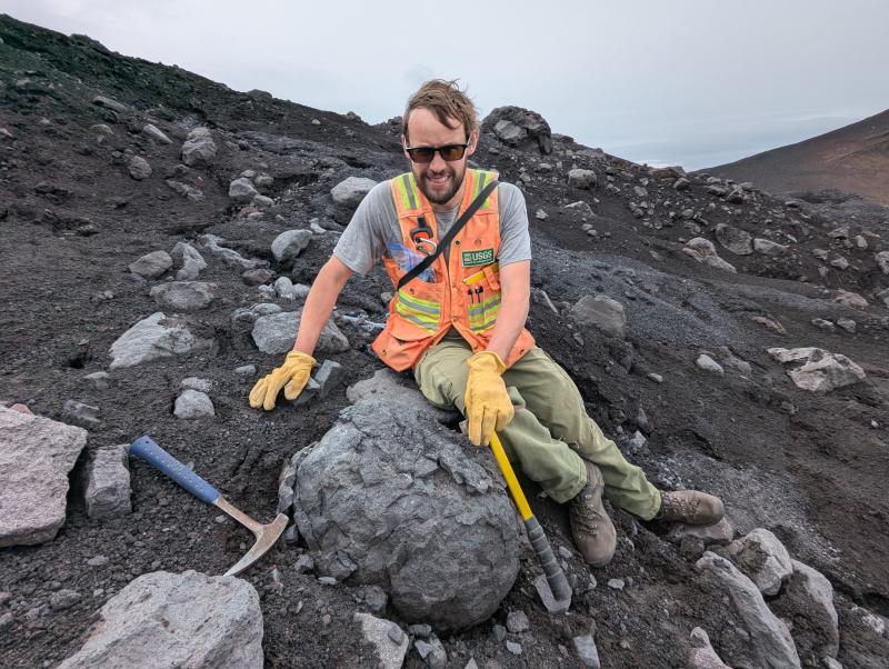 AVO geologist Matthew Loewen examining products of the 2023 Shishaldin ...